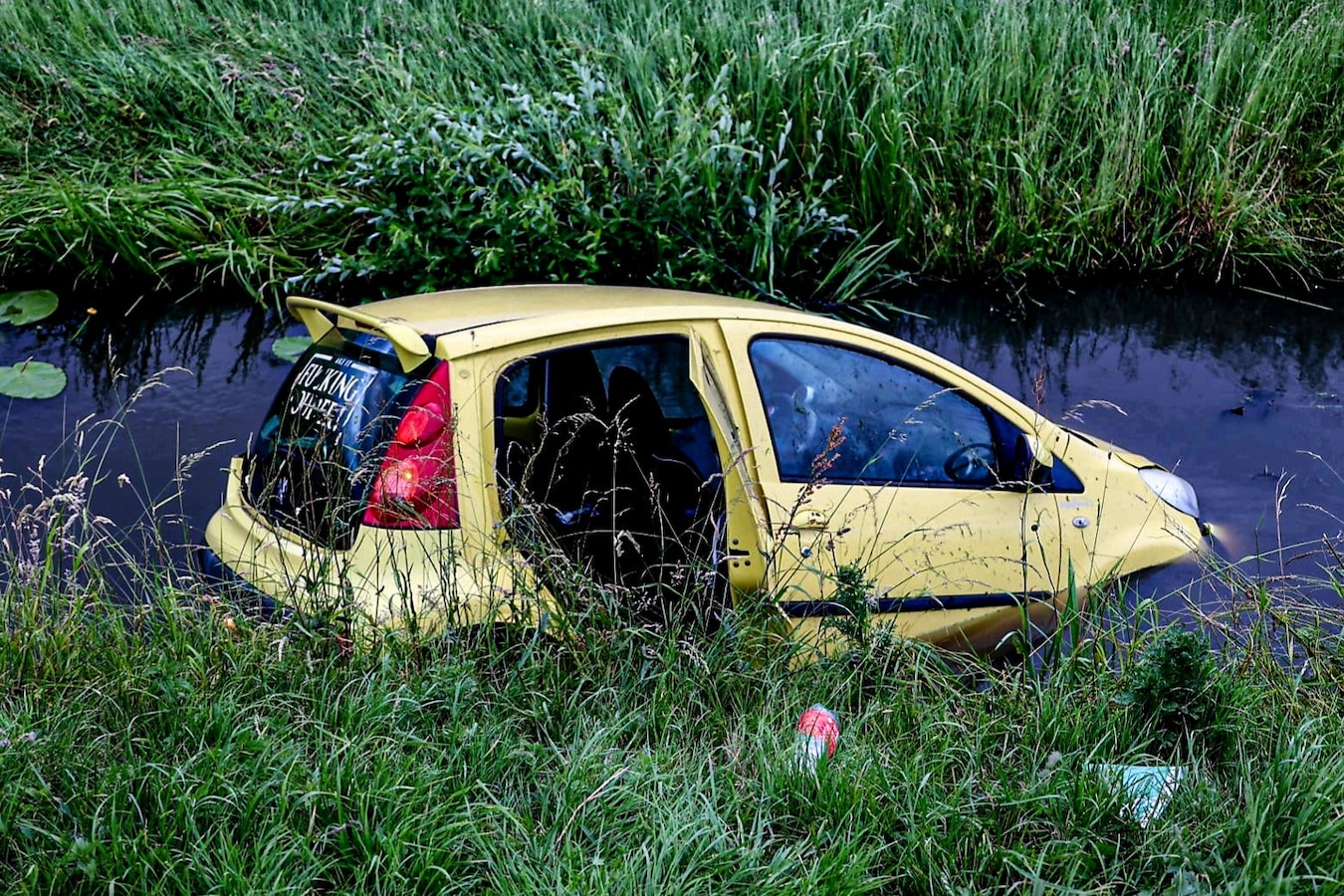 Auto te water in Lopik, omstanders helpen bestuurster op het droge ...