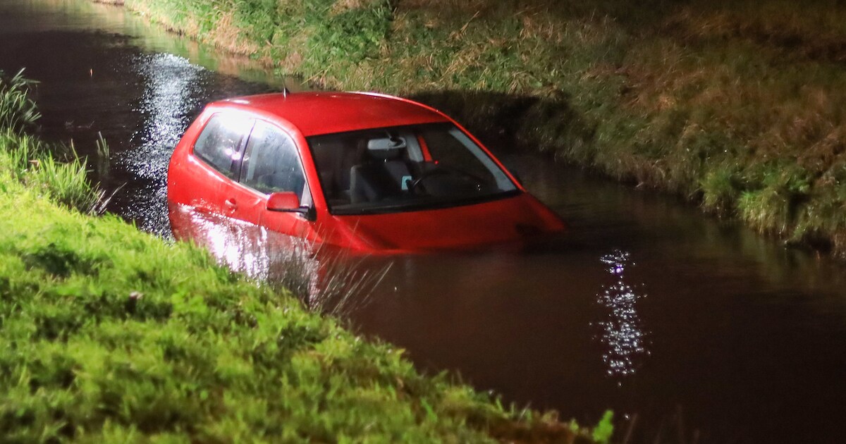 Vervelend nat pak; automobilist rijdt sloot in naast donkere weg in ...
