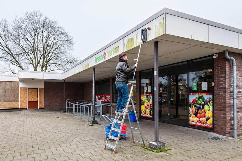 Verrommelde buurt met dichtgespijkerd winkelcentrum doorn in oog in ...