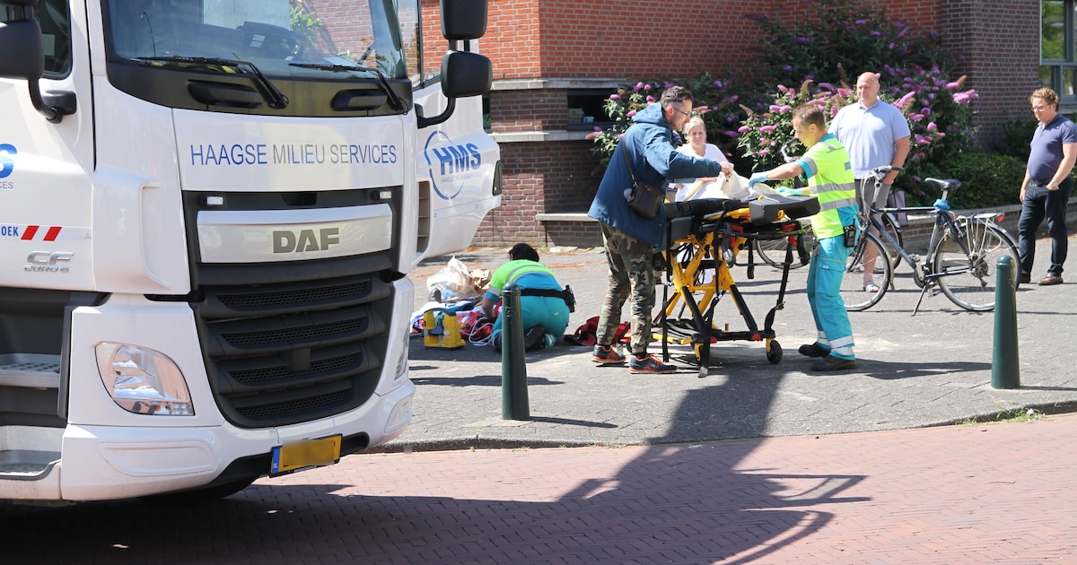 Vuilnisman valt in ondergrondse container, omstanders hijsen hem uit de ...
