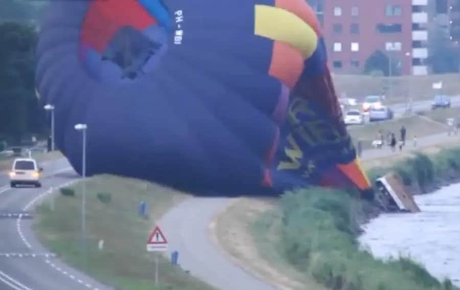 Luchtballon scheert rakelings langs huizen en landt in berm van drukke ...
