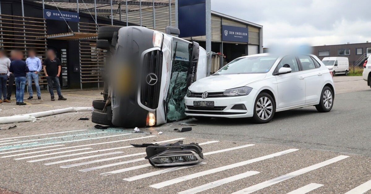 Bestelbus belandt op zijkant na botsing; twee gewonden | Tiel | AD.nl