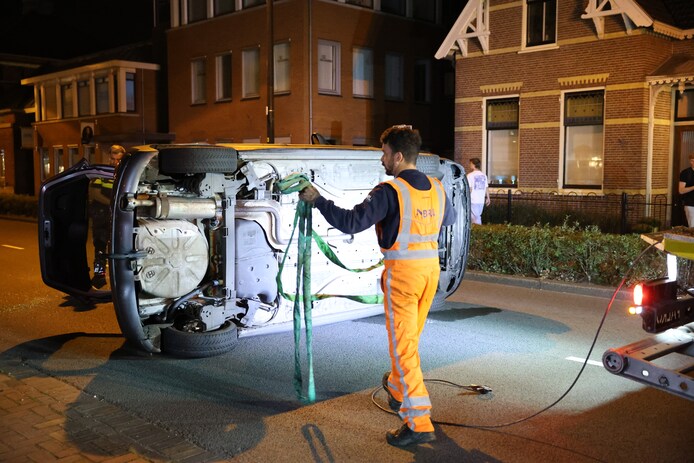 Auto belandt op zijkant na botsing tegen geparkeerde auto | Voorschoten ...