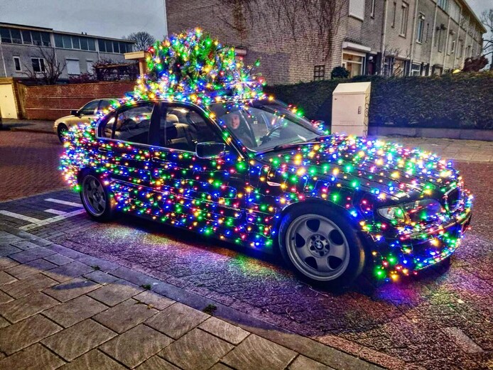 Auto vol lampjes en kerstboom op het dak van de weg geplukt: leuk om te ...