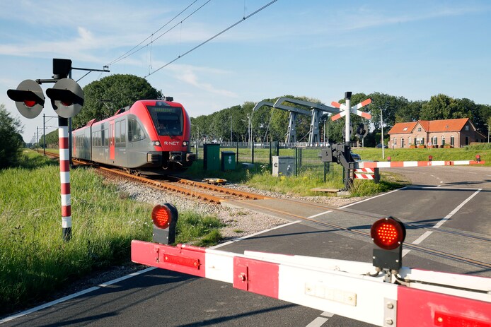 Vrachtwagen rijdt slagboom stuk, trein MerwedeLingelijn stapvoets langs ...