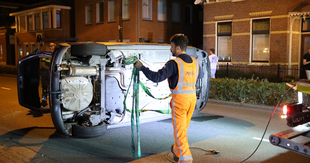 Auto belandt op zijkant na botsing tegen geparkeerde auto | Voorschoten ...
