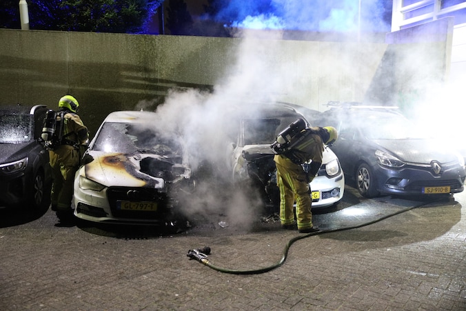 Twee auto's beschadigd door brand op parkeerplaats bij flats in Den ...